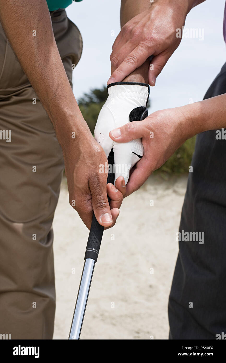 Two people holding a golf club Stock Photo - Alamy