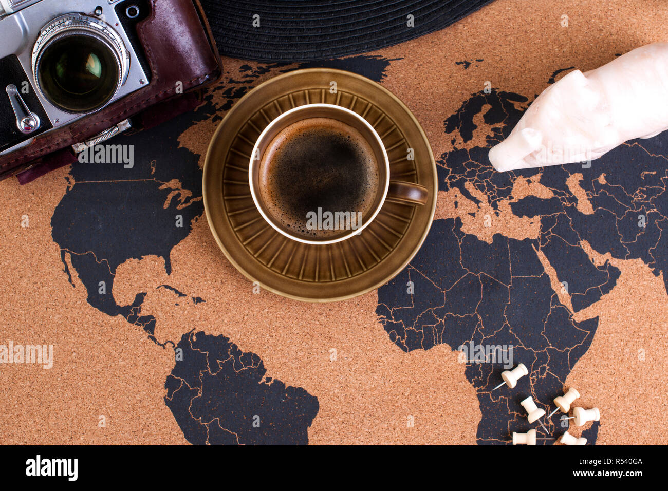 A cup of fragrant coffee on the map, an old camera and a route plan, a ...