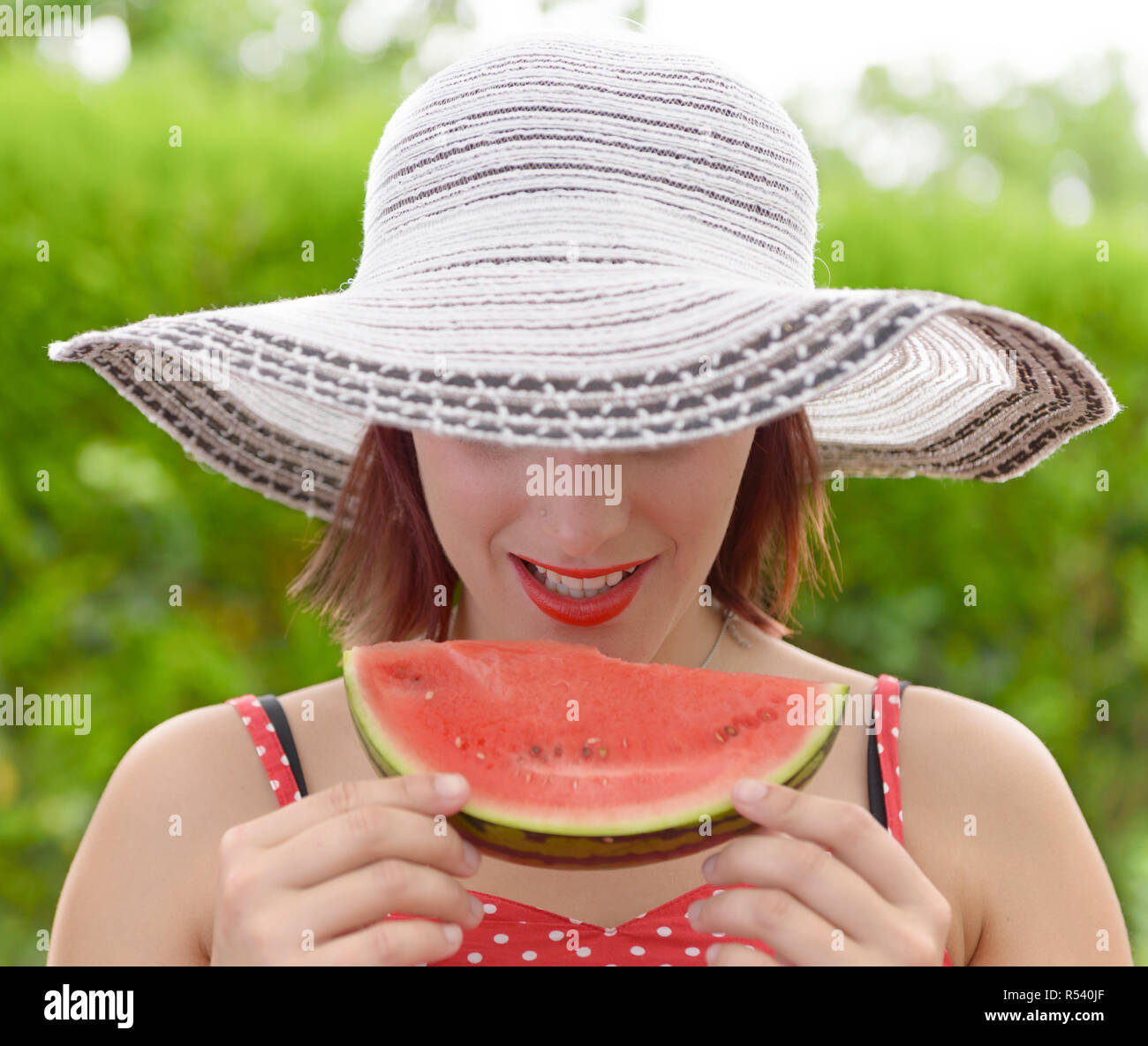 Beautiful girl eating a watermelon Stock Photo - Alamy