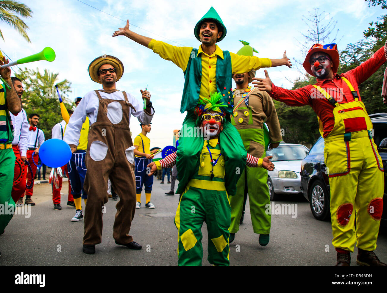 A street carnival with a parade of customs, clowns, circus jugglers ...