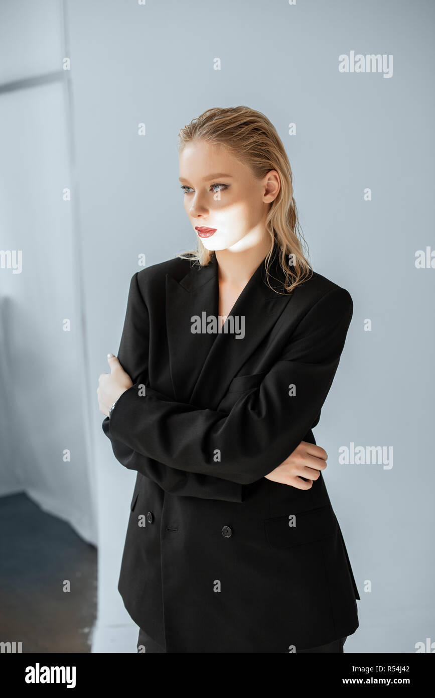 attractive model in formal wear with light beam on face posing for ...