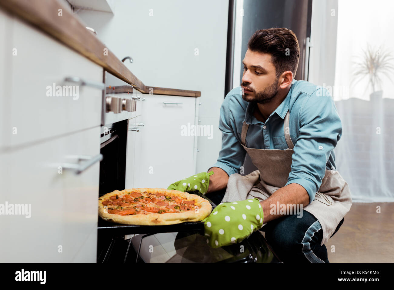 Man taking pizza out oven hi-res stock photography and images - Alamy