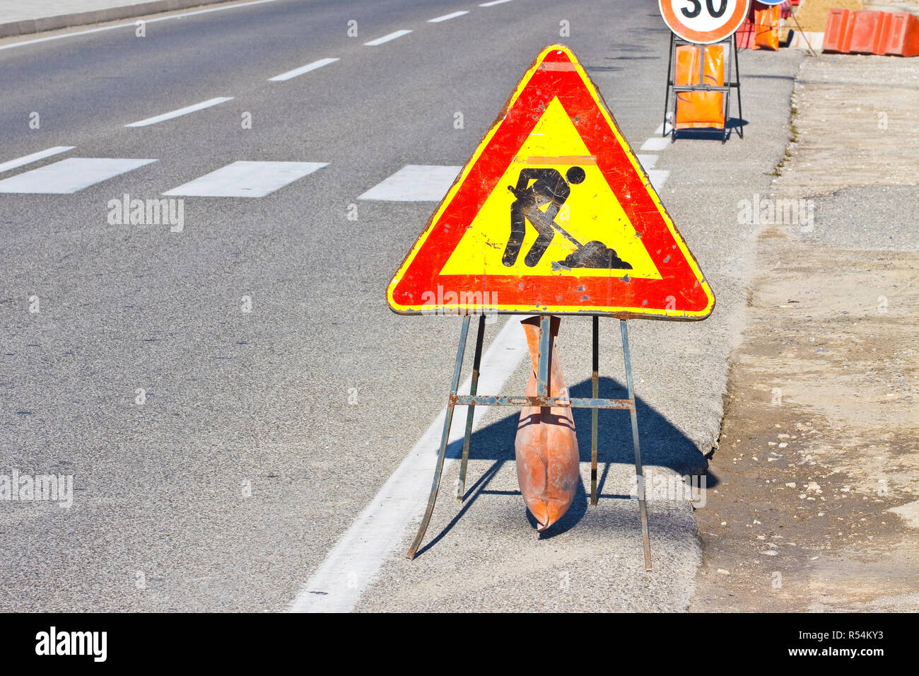 Construction site on tarmac road with yellow and red road sign Stock ...