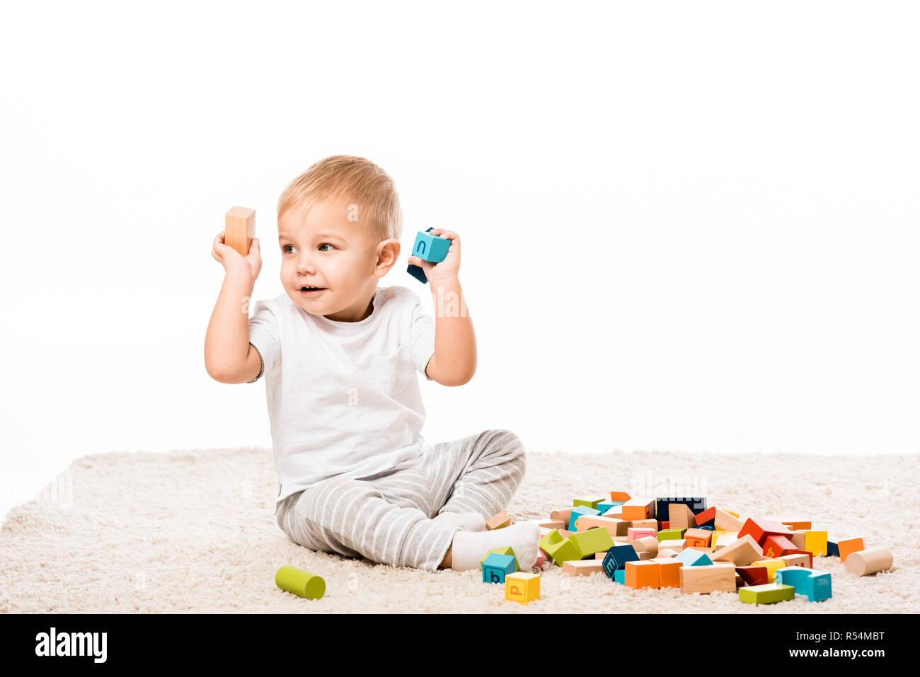 adorable little boy playing with wooden blocks on carpet isolated on ...
