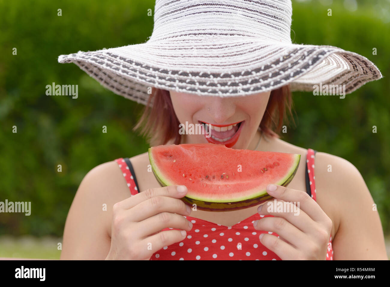 Beautiful girl eating a watermelon Stock Photo - Alamy