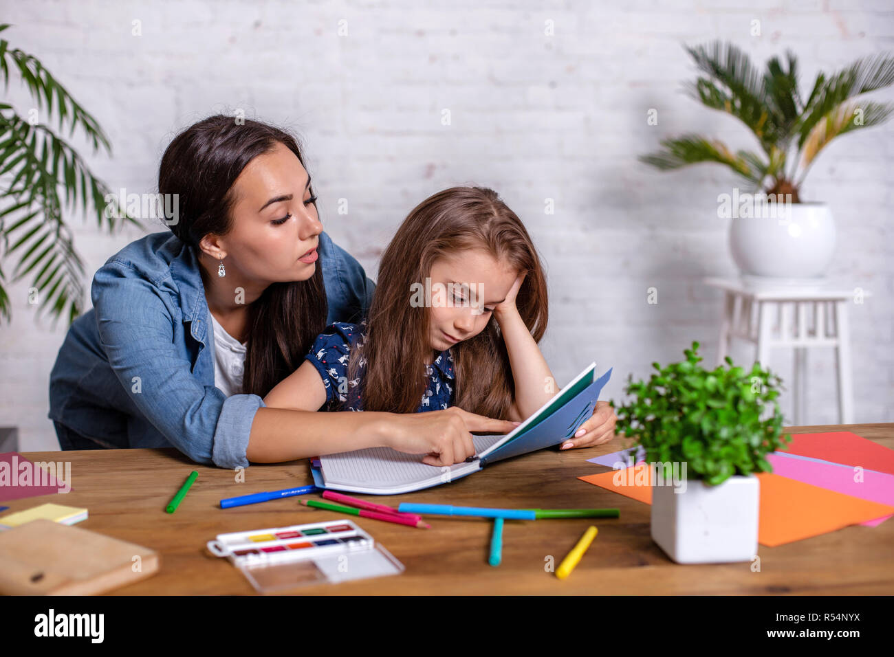 Mother becoming frustrated with daughter whilst doing homework sitting ...