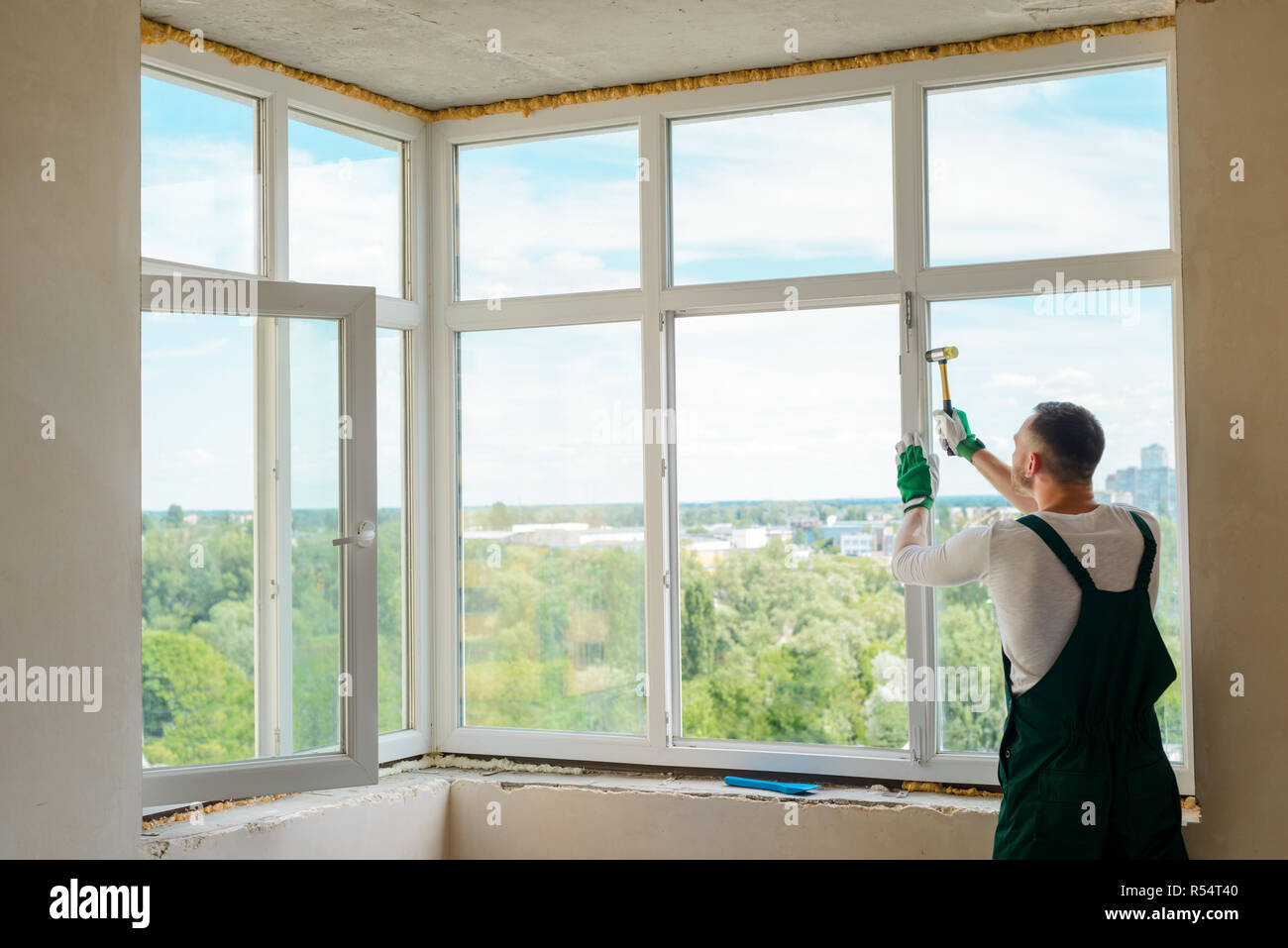 Worker is installing a window Stock Photo - Alamy
