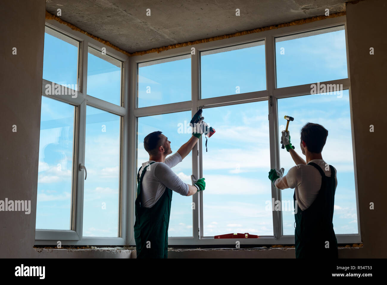Two workers installing a window Stock Photo - Alamy