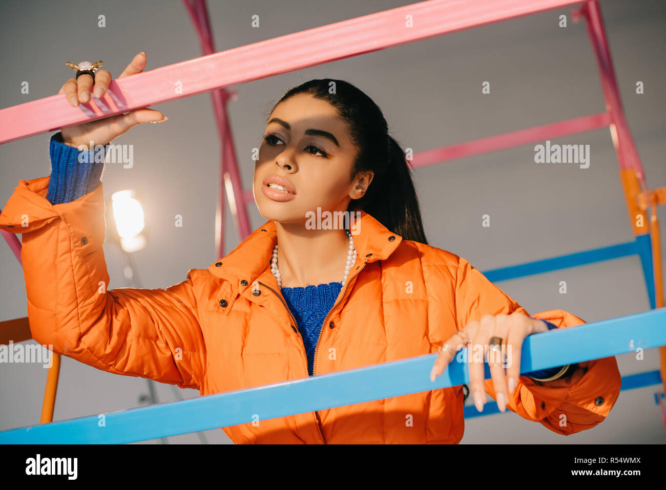 beautiful african american female model in orange winter jacket posing ...