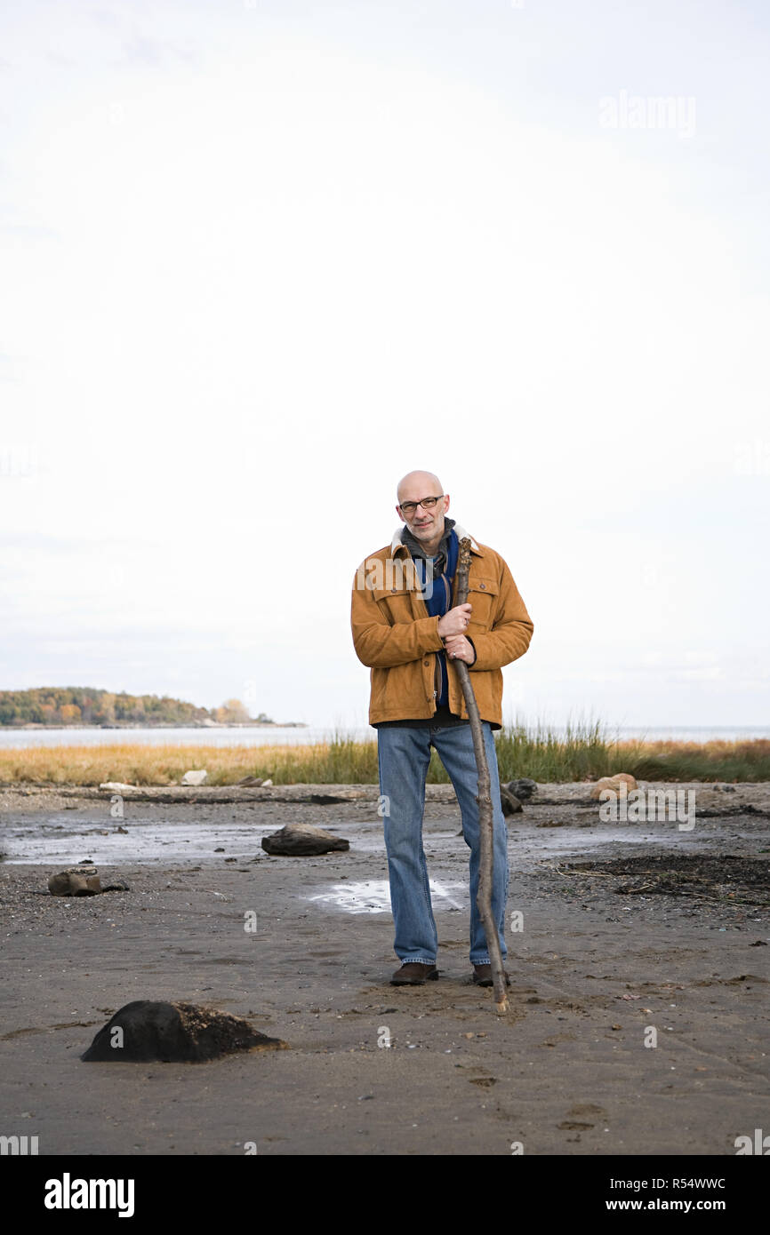 Mature man leaning on a stick Stock Photo - Alamy