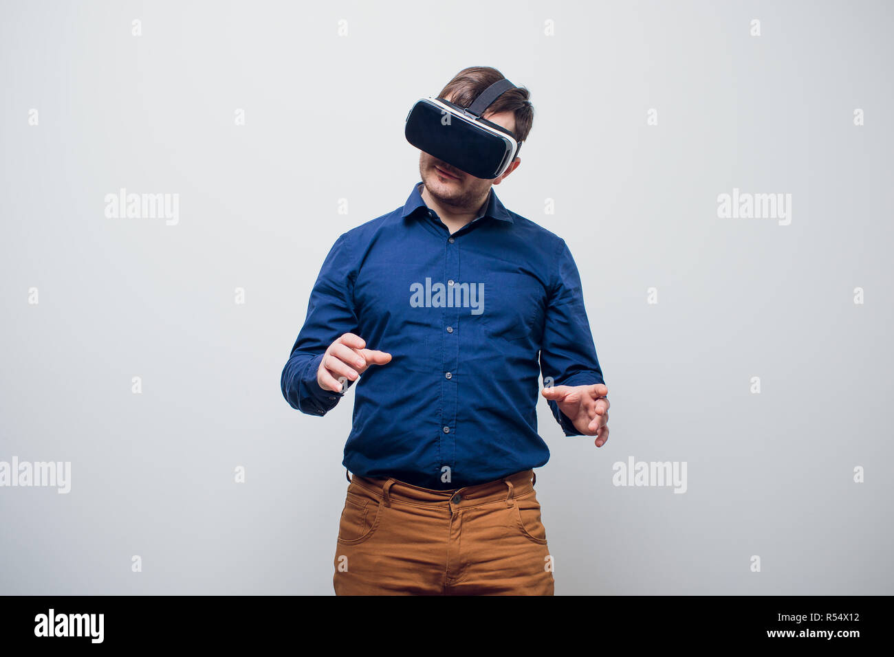 Young man using VR glasses headset trying to touch objects in virtual ...