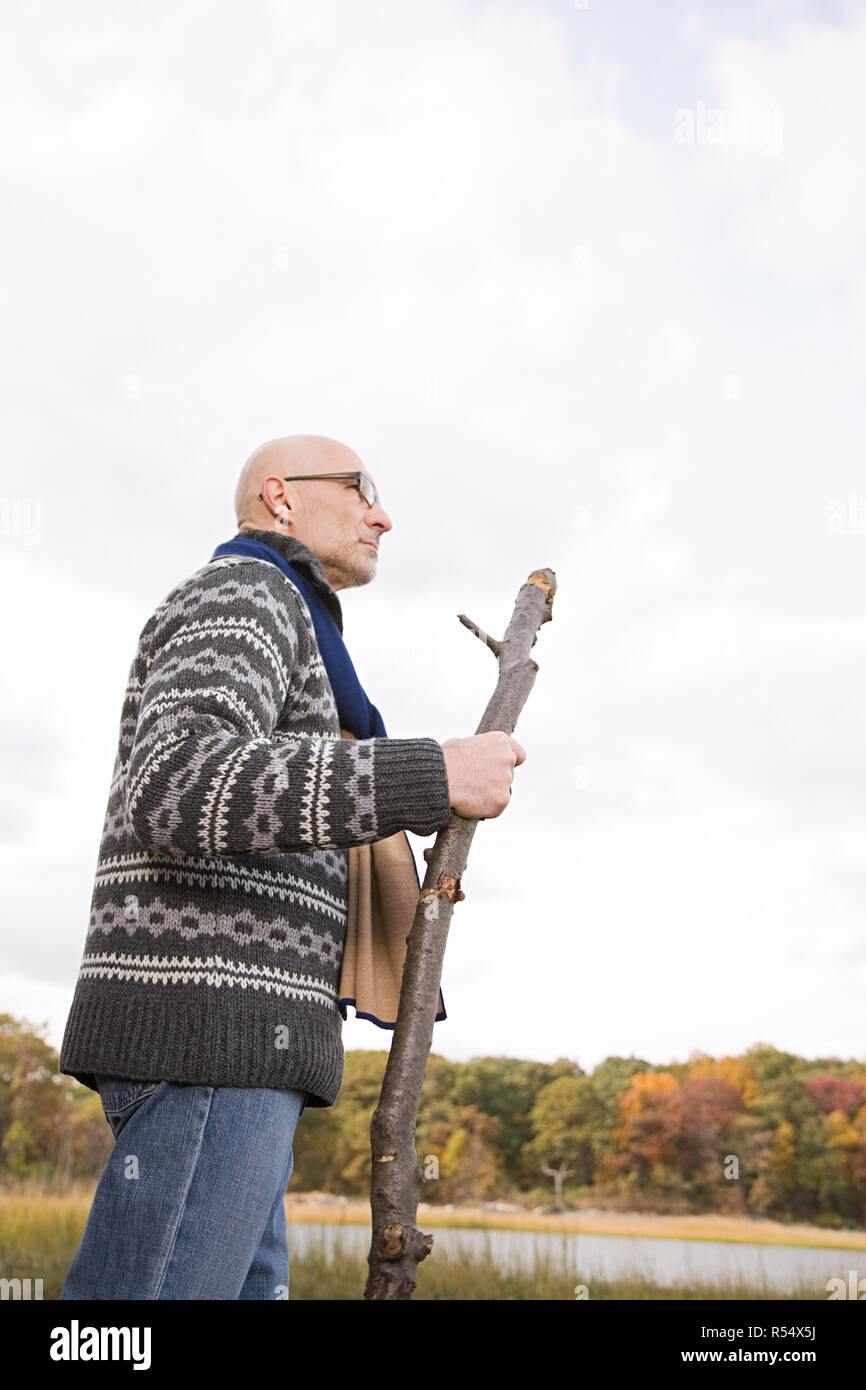 Mature man holding a stick Stock Photo - Alamy