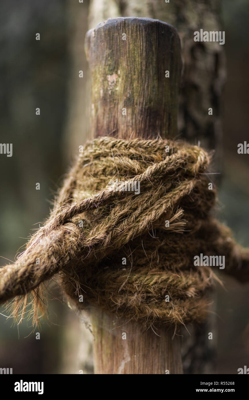 A knot of rope around a wooden post Stock Photo - Alamy