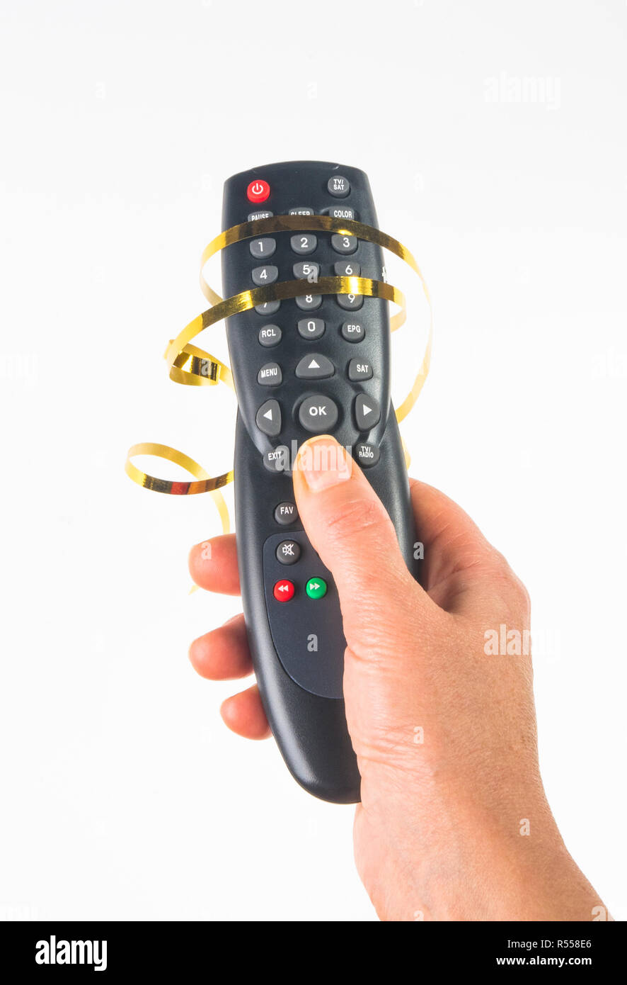 hand holding a remote control in a festive gold ribbon on white ...