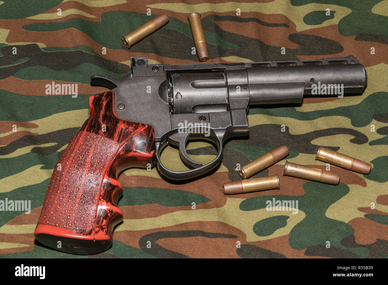 Revolver on camouflage background. Pneumatic gun 4,5 mm Stock Photo - Alamy