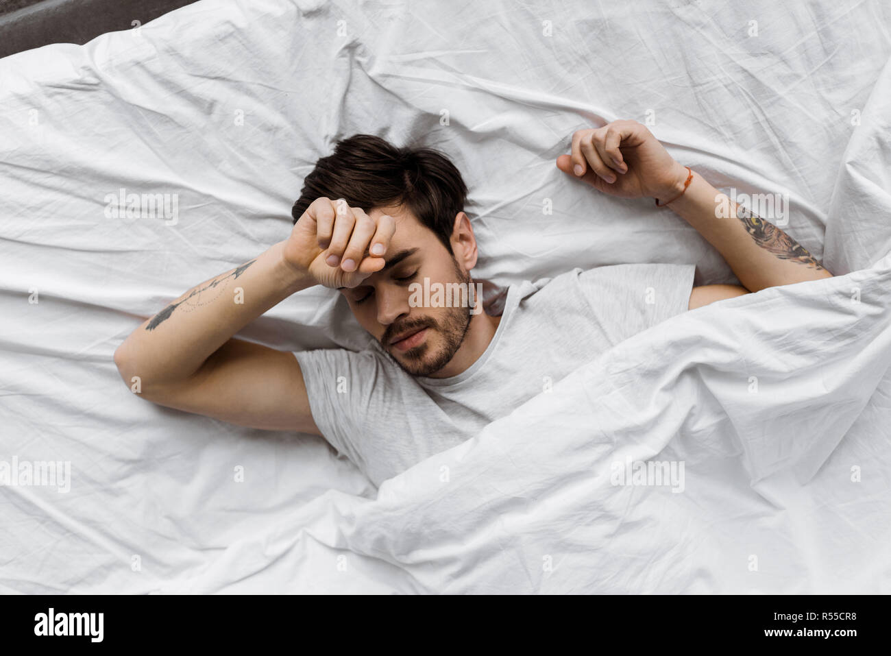 top view of sleeping young man lying under blanket in bed at home Stock ...