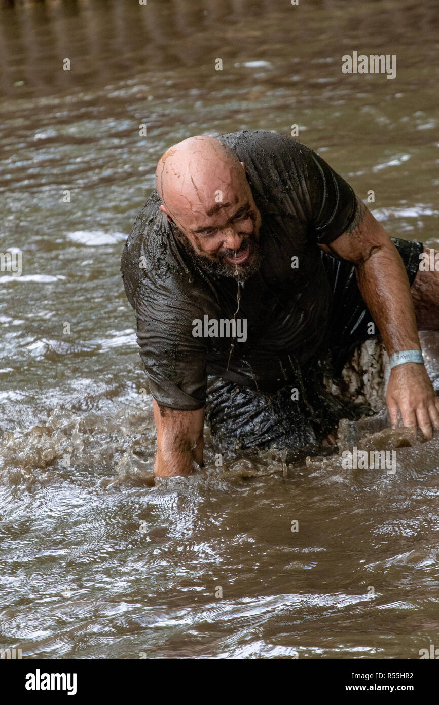 Male mud runner washes at a water crossing Stock Photo - Alamy