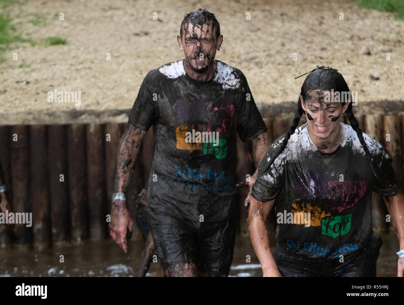 A mud covered couple during an obstacle course run Stock Photo - Alamy