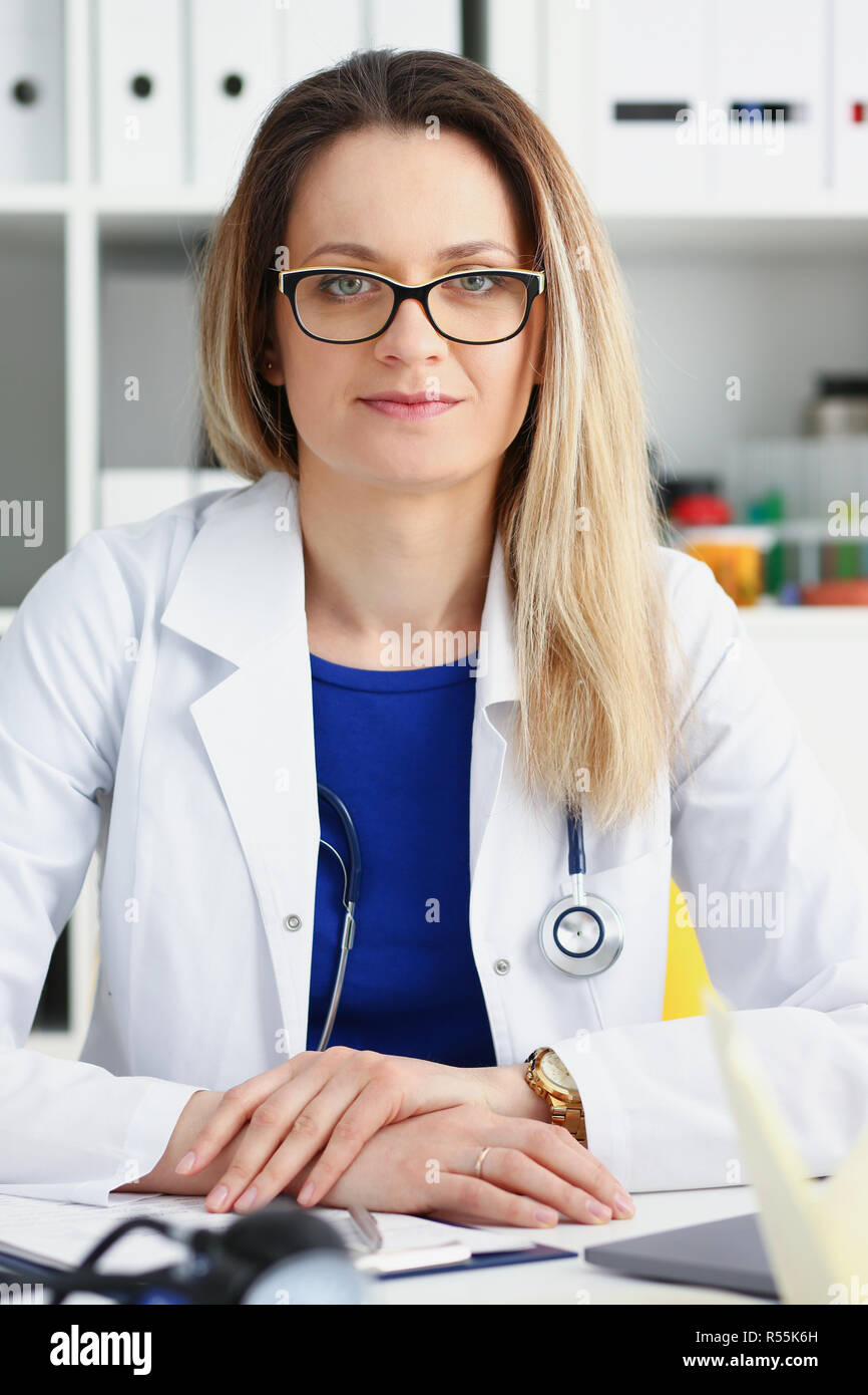 Beautiful smiling female doctor sit at workplace Stock Photo - Alamy