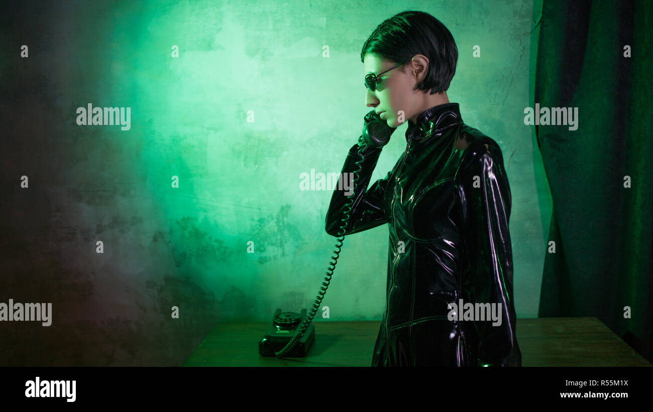 Girl hacker in black leather. Young woman in matrix style suit, digital ...