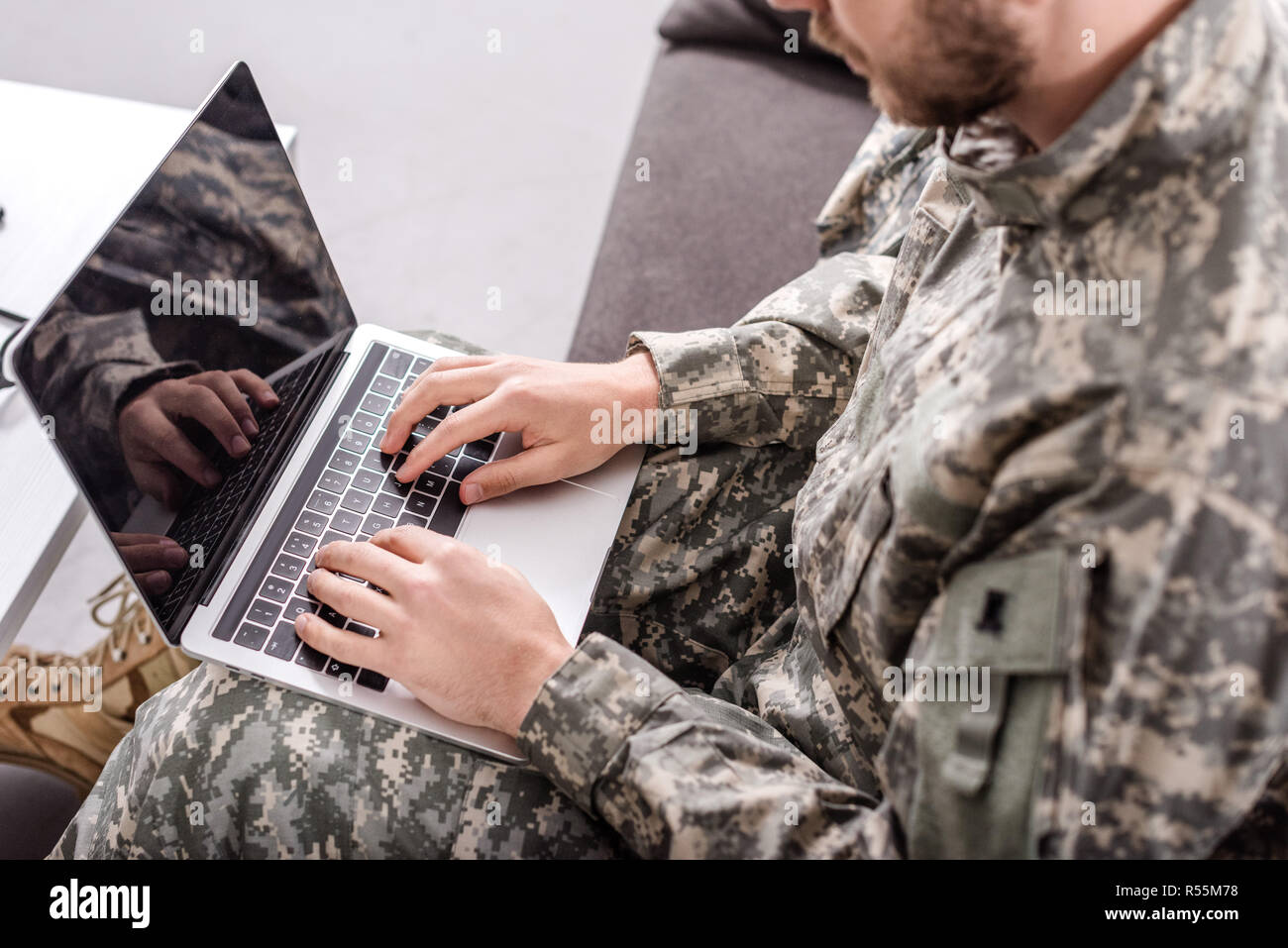 partial view of army soldier using laptop on couch Stock Photo - Alamy