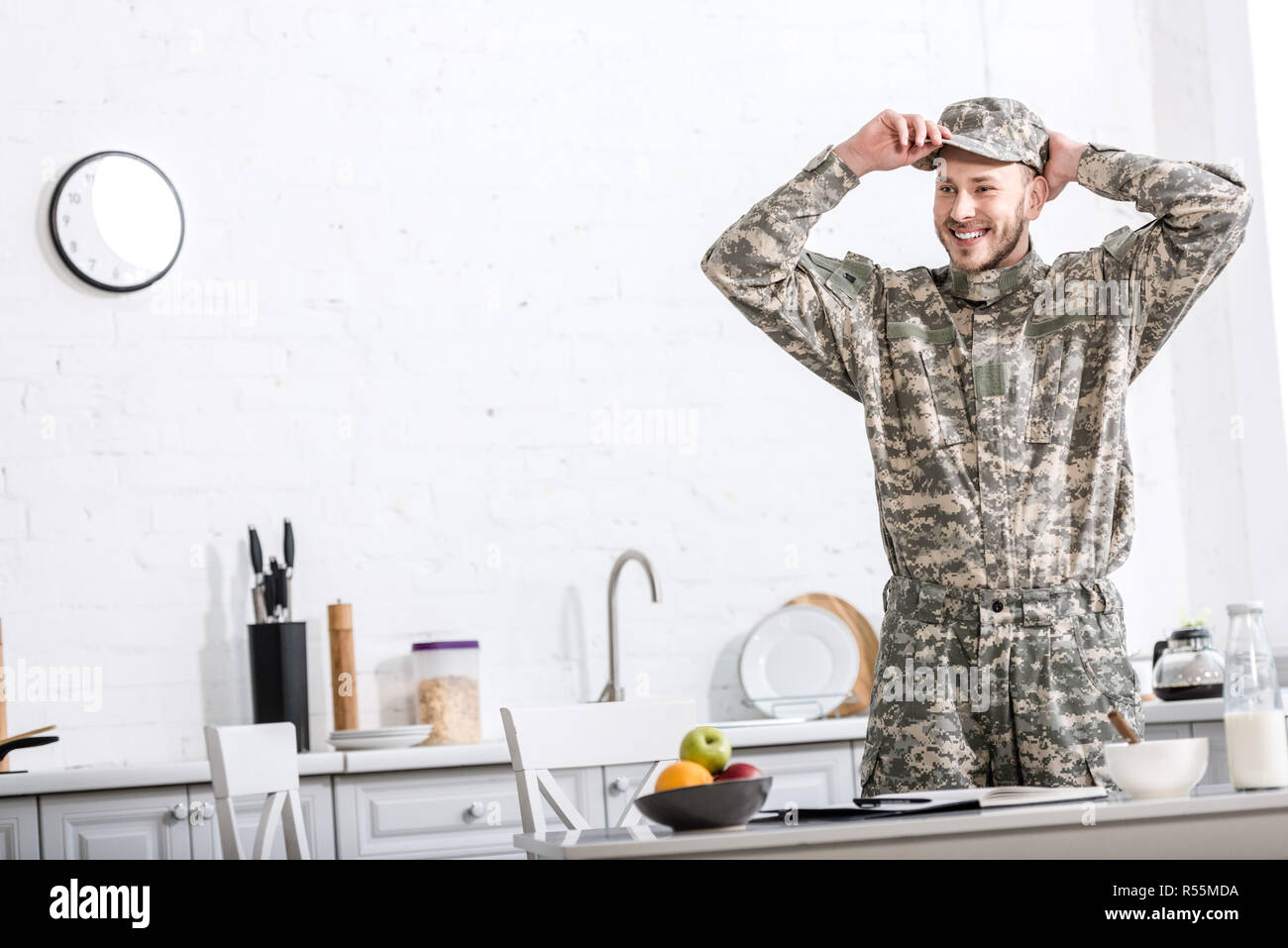 army soldier putting on hat in kitchen Stock Photo - Alamy