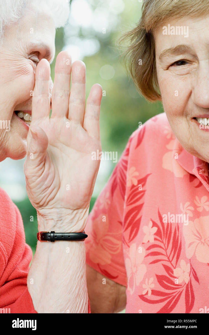 Two senior women sharing a secret Stock Photo - Alamy