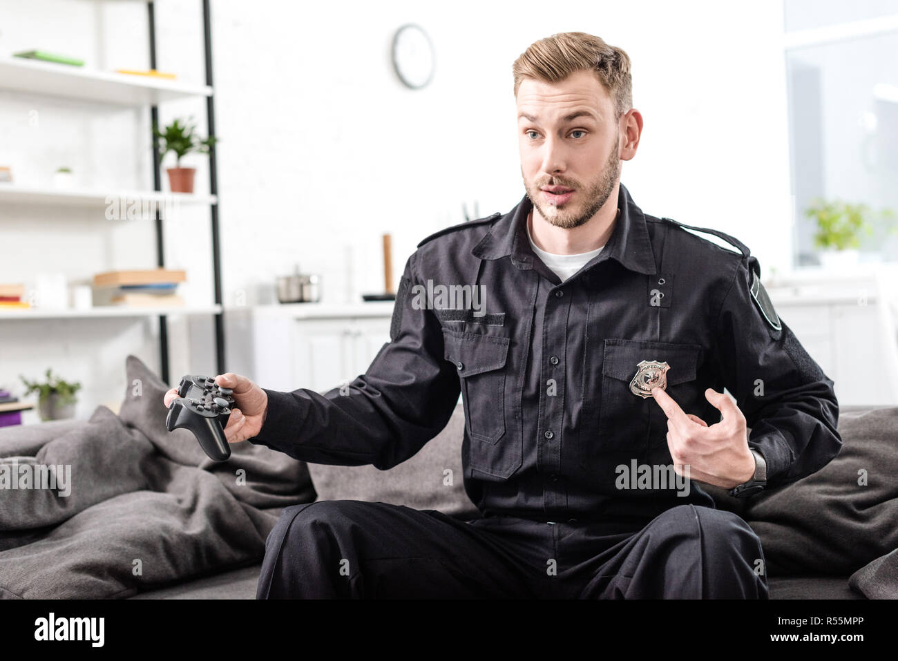 surprised police officer playing video game and pointing at police ...