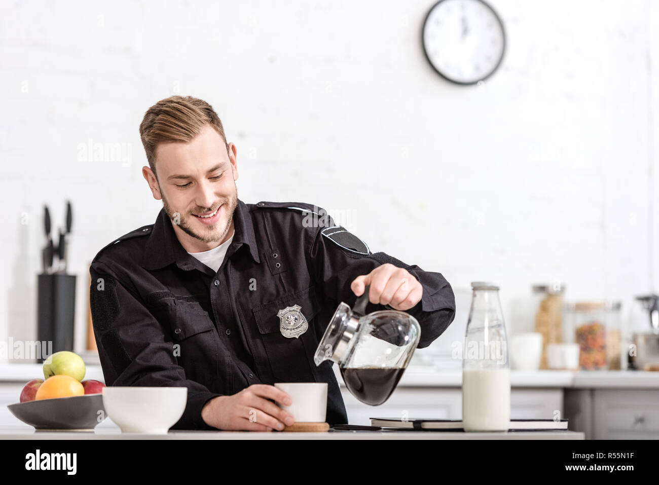 smiling police officer pouring filtered coffee from glass pot at ...