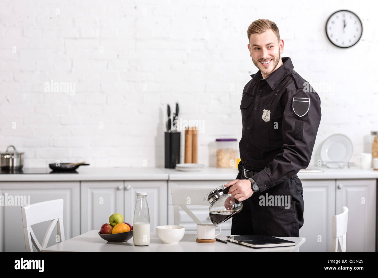smiling handsome policeman pouring filtered coffee from glass pot at ...