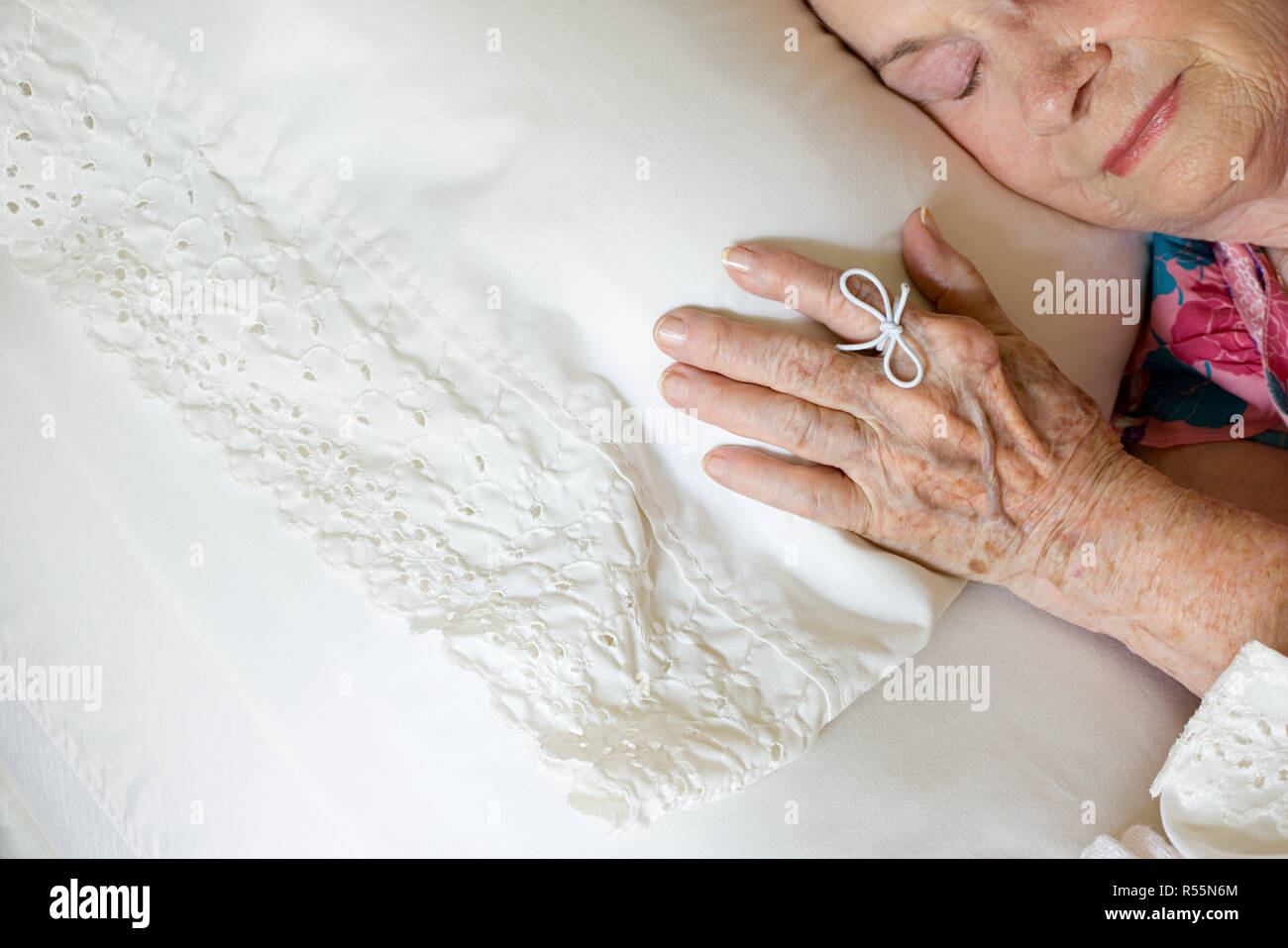 Elderly woman sleeping with string on her finger Stock Photo - Alamy