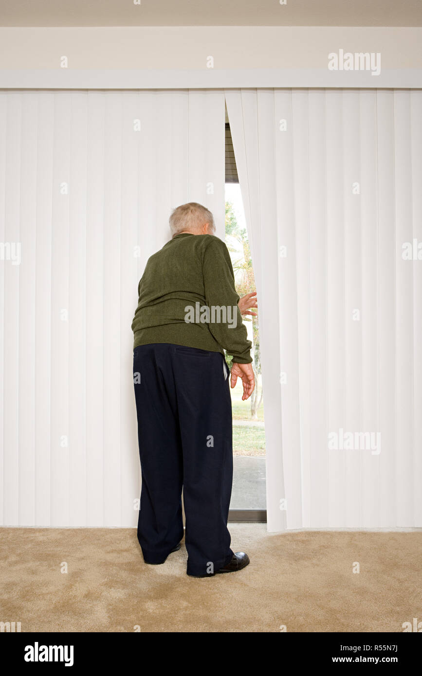 Worried man peeking out window hi-res stock photography and images - Alamy