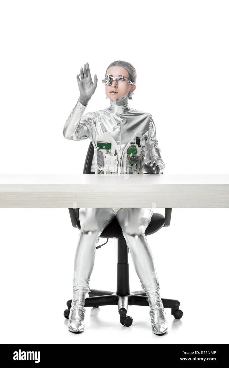 cyborg sitting at table and touching something isolated on white ...