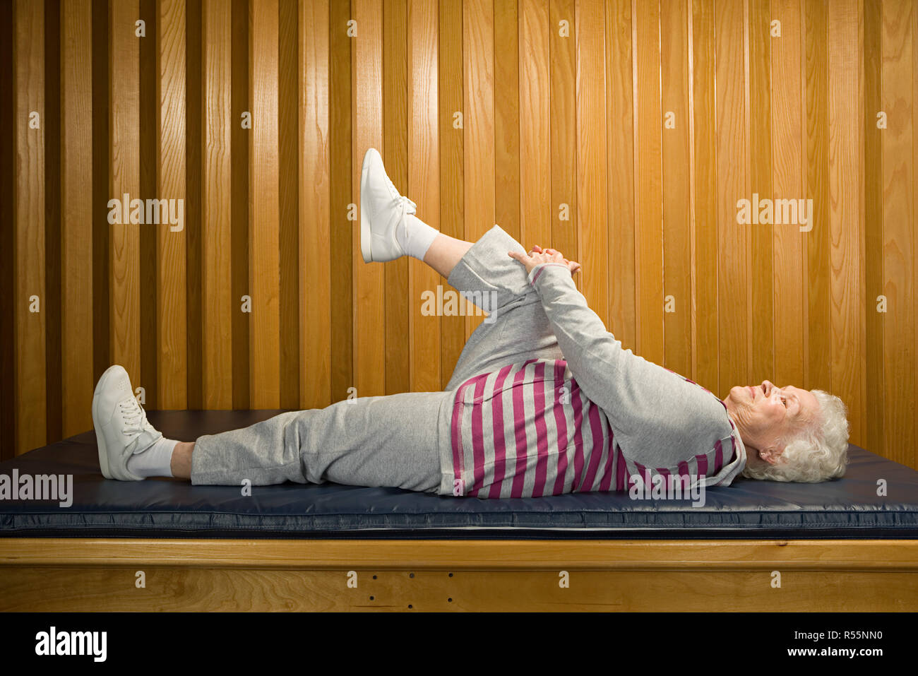 Woman lying down stretching Stock Photo - Alamy