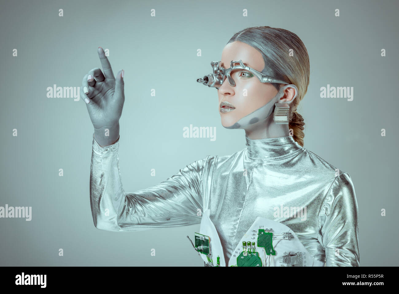 futuristic silver robot gesturing with hand and looking away isolated ...