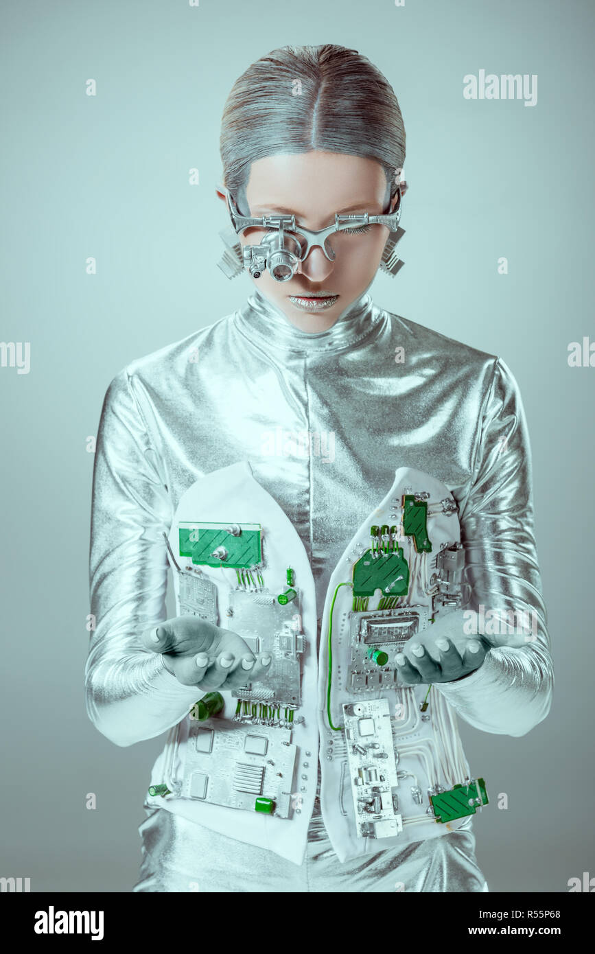 futuristic silver robot looking at hands isolated on grey, future ...