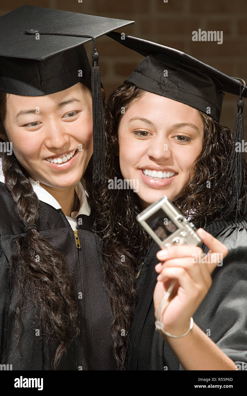 Two female graduates taking a photograph Stock Photo - Alamy