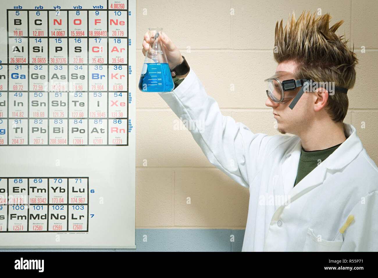 Male student holding up a chemical liquid Stock Photo - Alamy