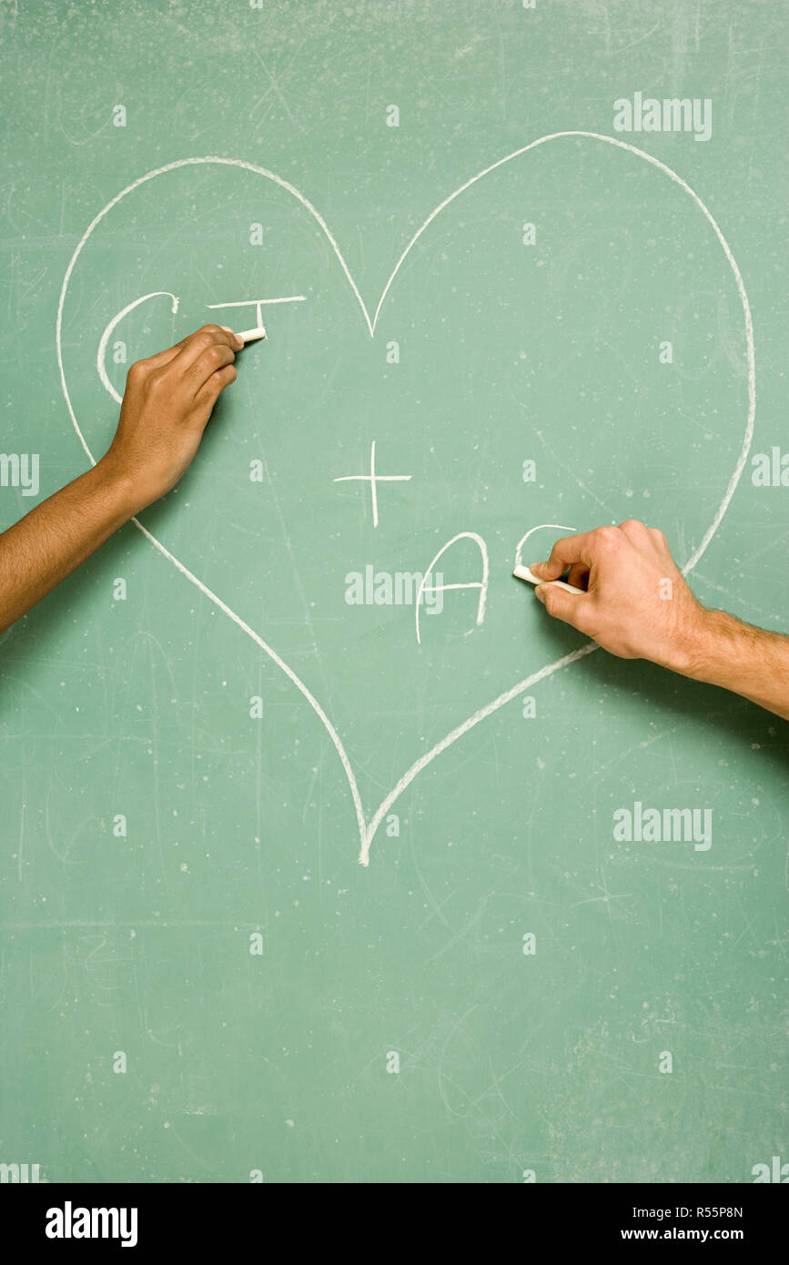 Two students drawing on blackboard Stock Photo - Alamy