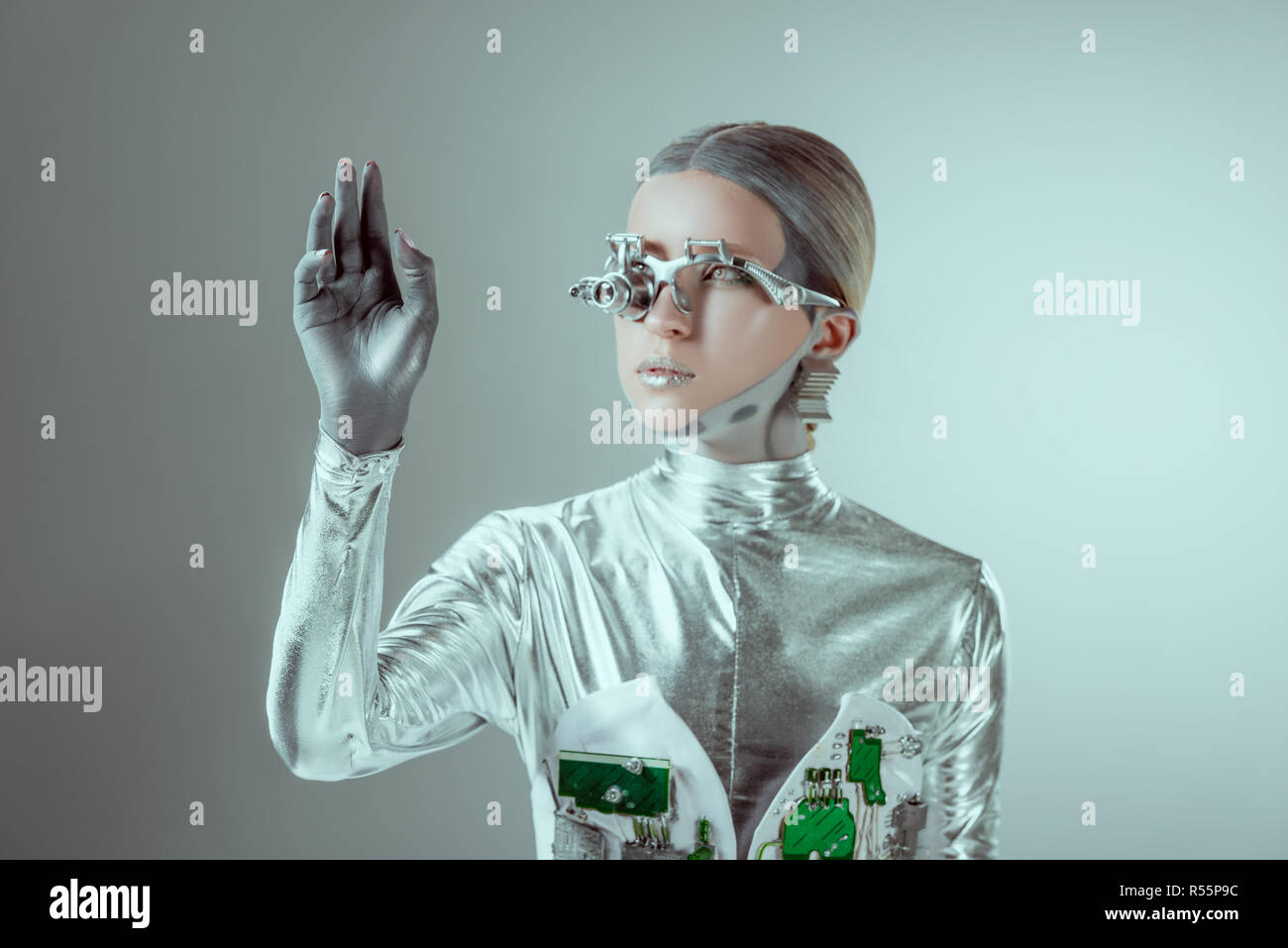 futuristic silver robot gesturing with hand and looking away isolated ...