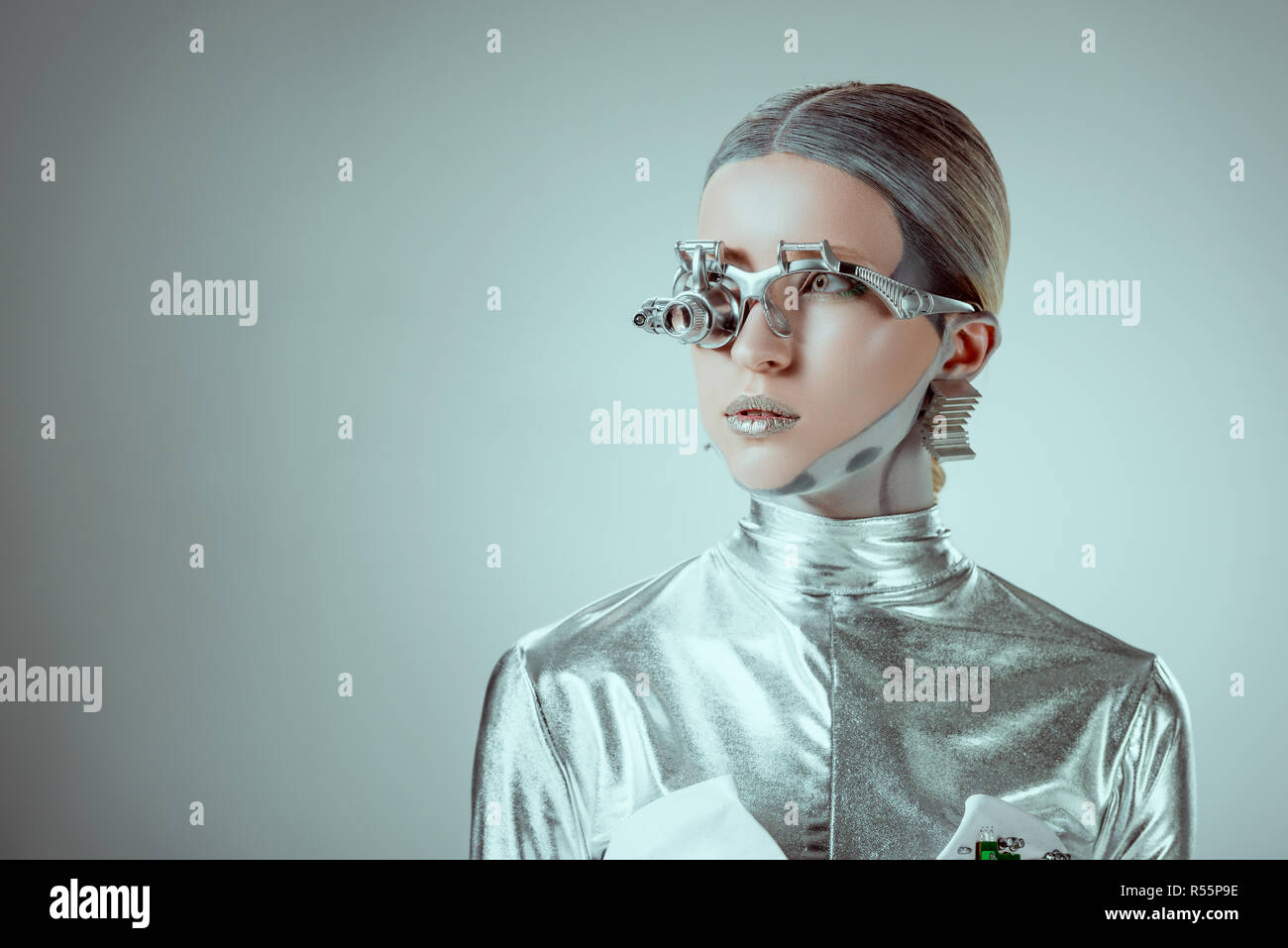 futuristic silver robot looking away isolated on grey, future ...