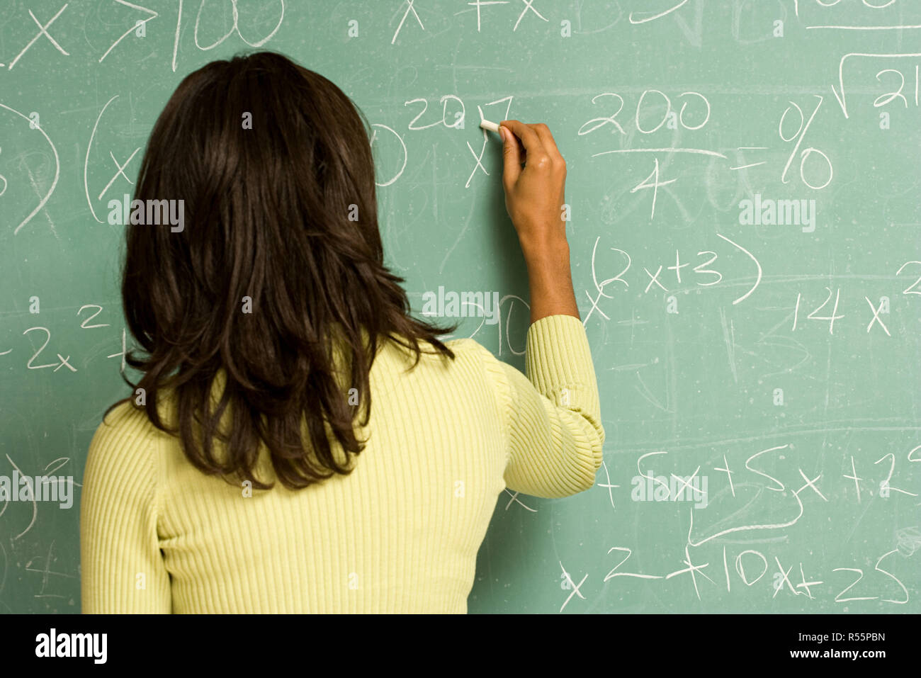 Female student writing on blackboard Stock Photo - Alamy