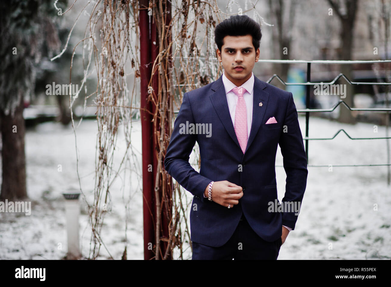 Elegant indian macho man model on suit and pink tie posed on winter day ...