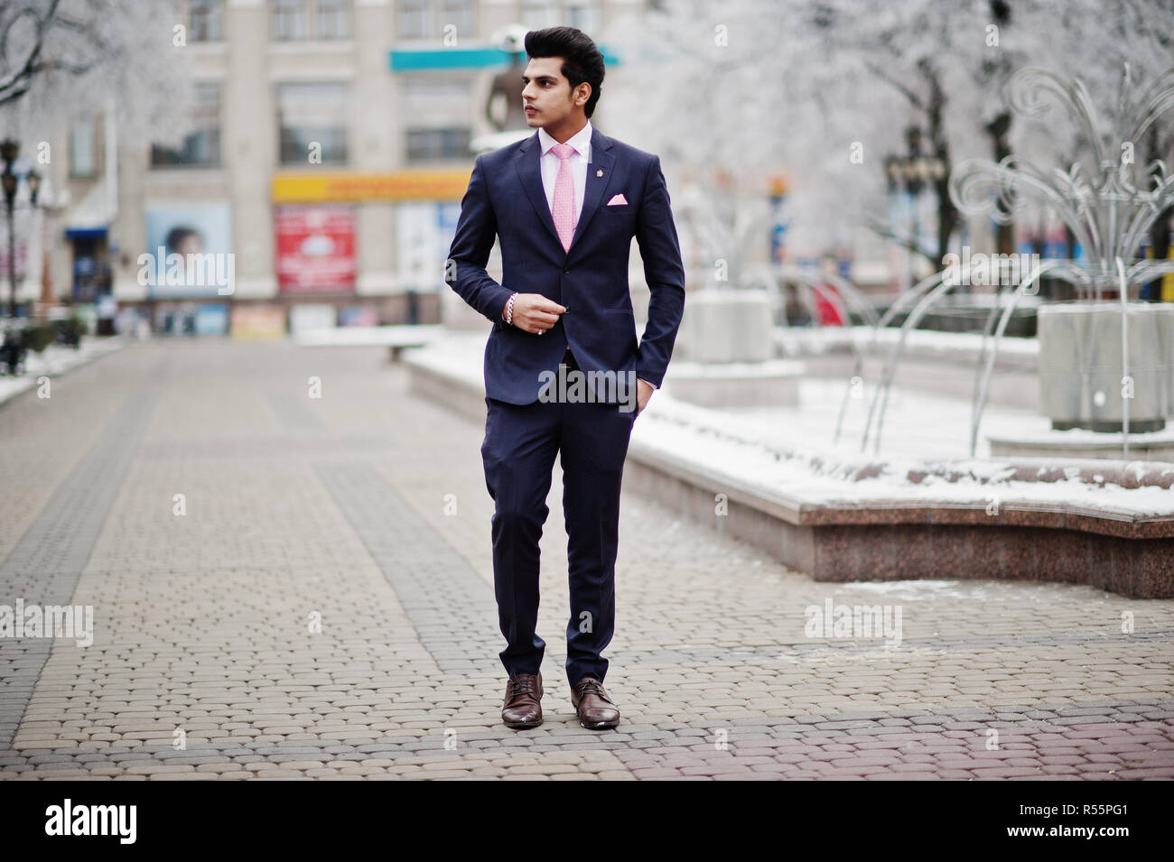 Elegant indian macho man model on suit and pink tie posed on winter day ...