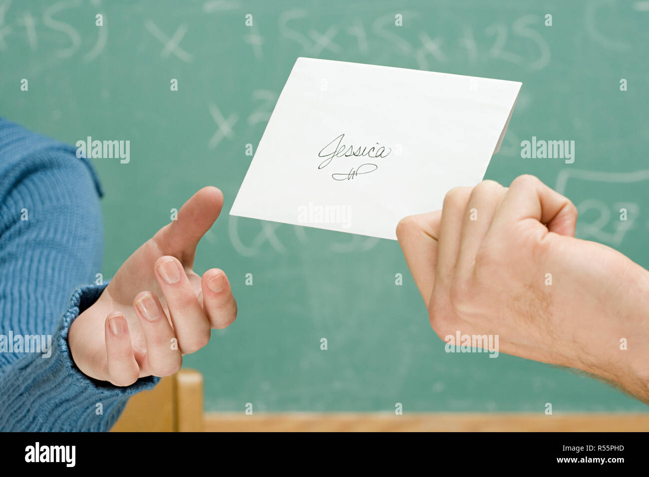 Boy passing girl a letter in class Stock Photo - Alamy