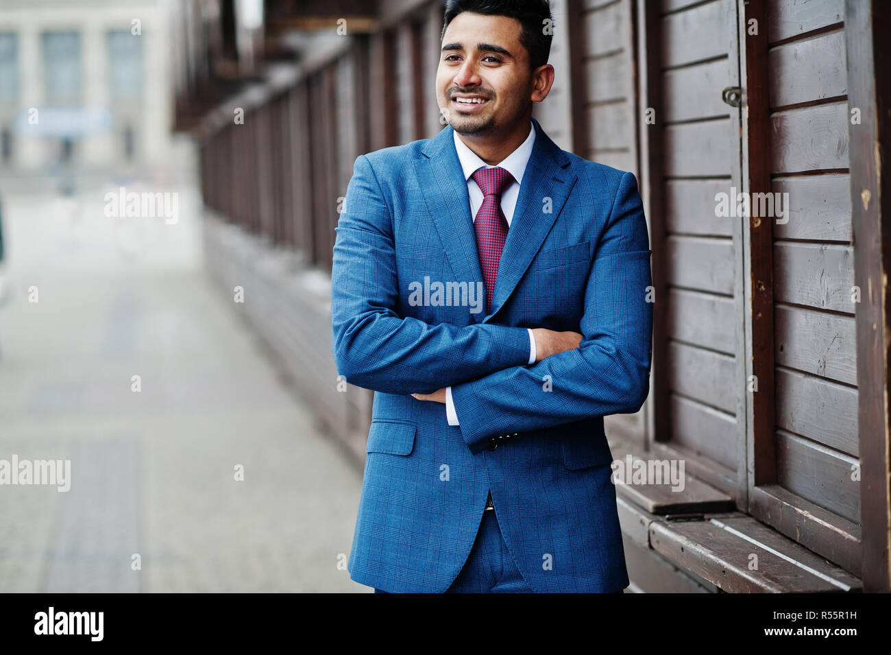 Elegant indian fashionable man model on suit posed against wooden ...