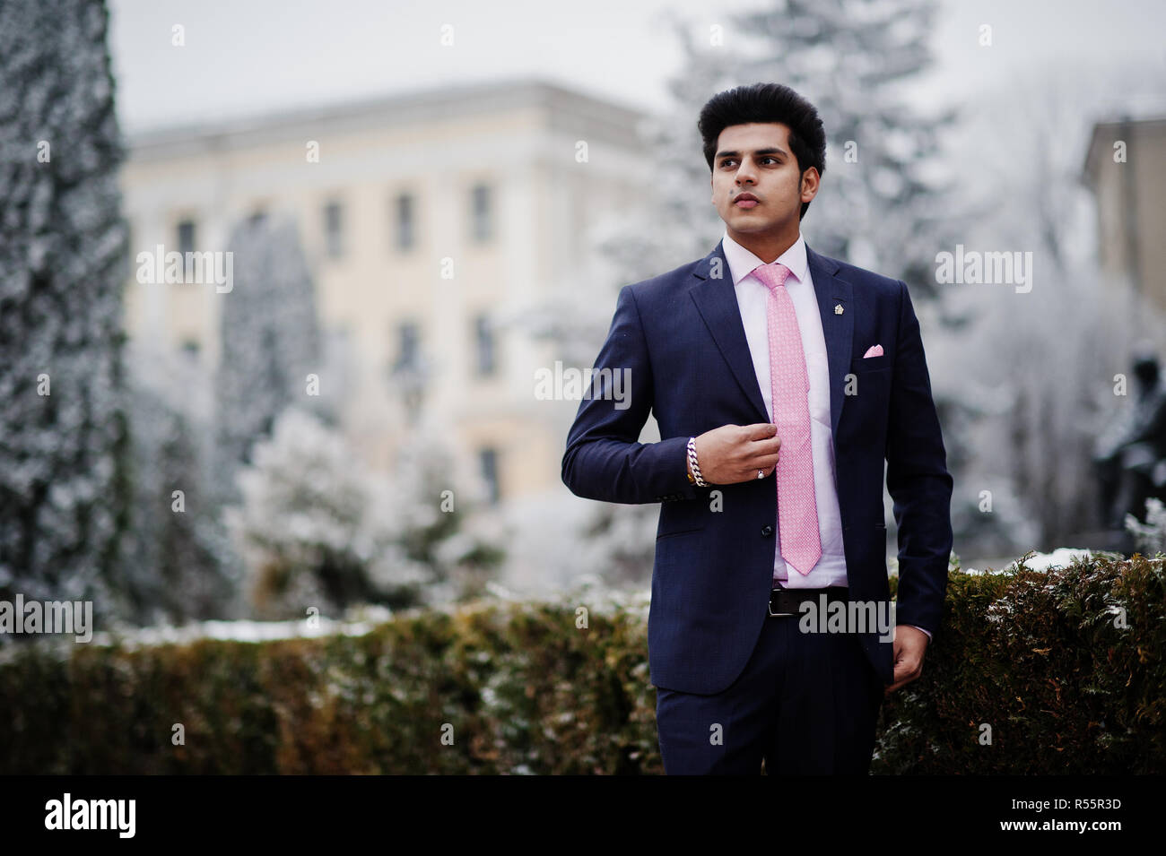 Elegant indian macho man model on suit and pink tie posed on winter day ...