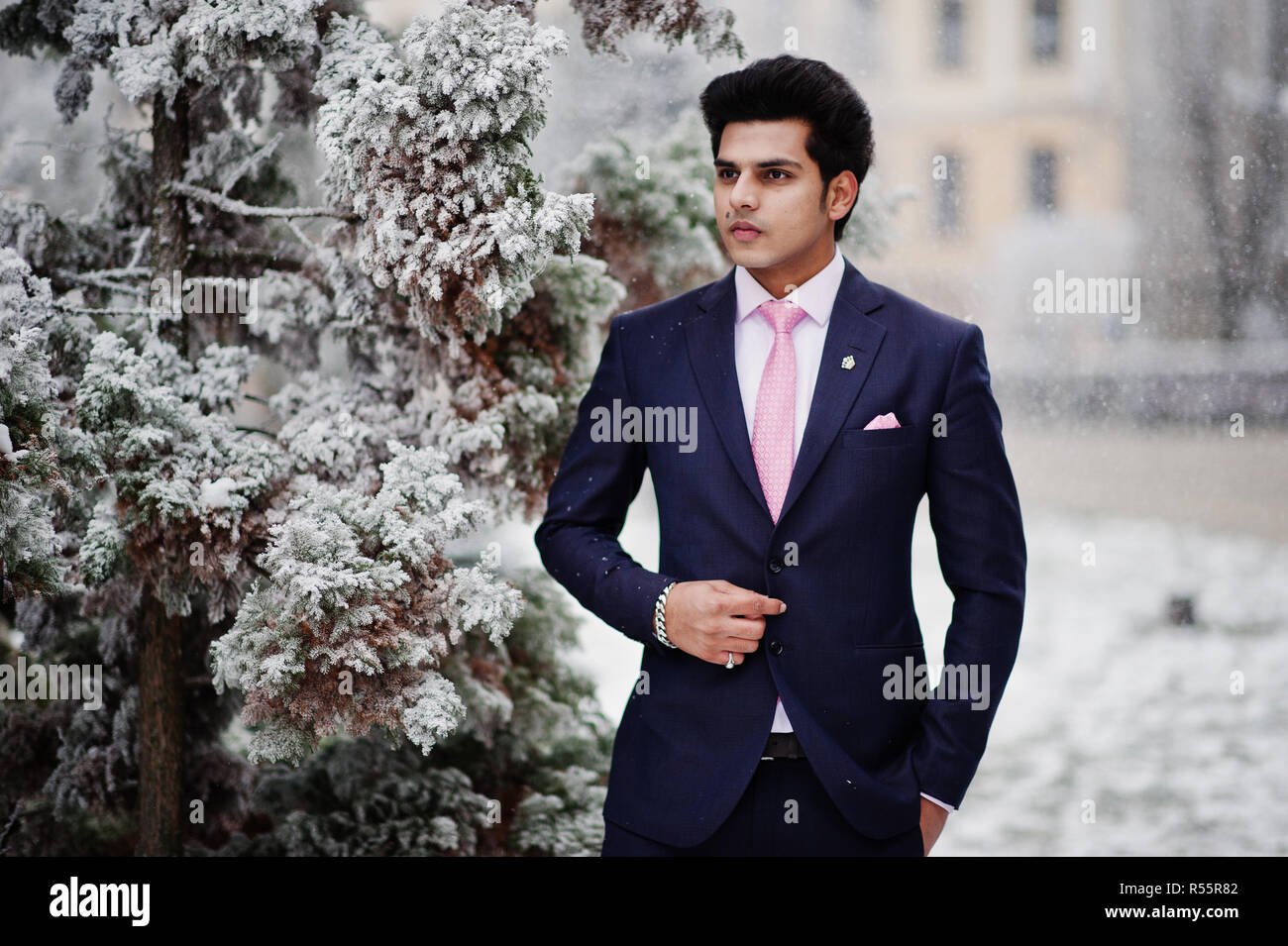 Elegant indian macho man model on suit and pink tie posed on winter day ...