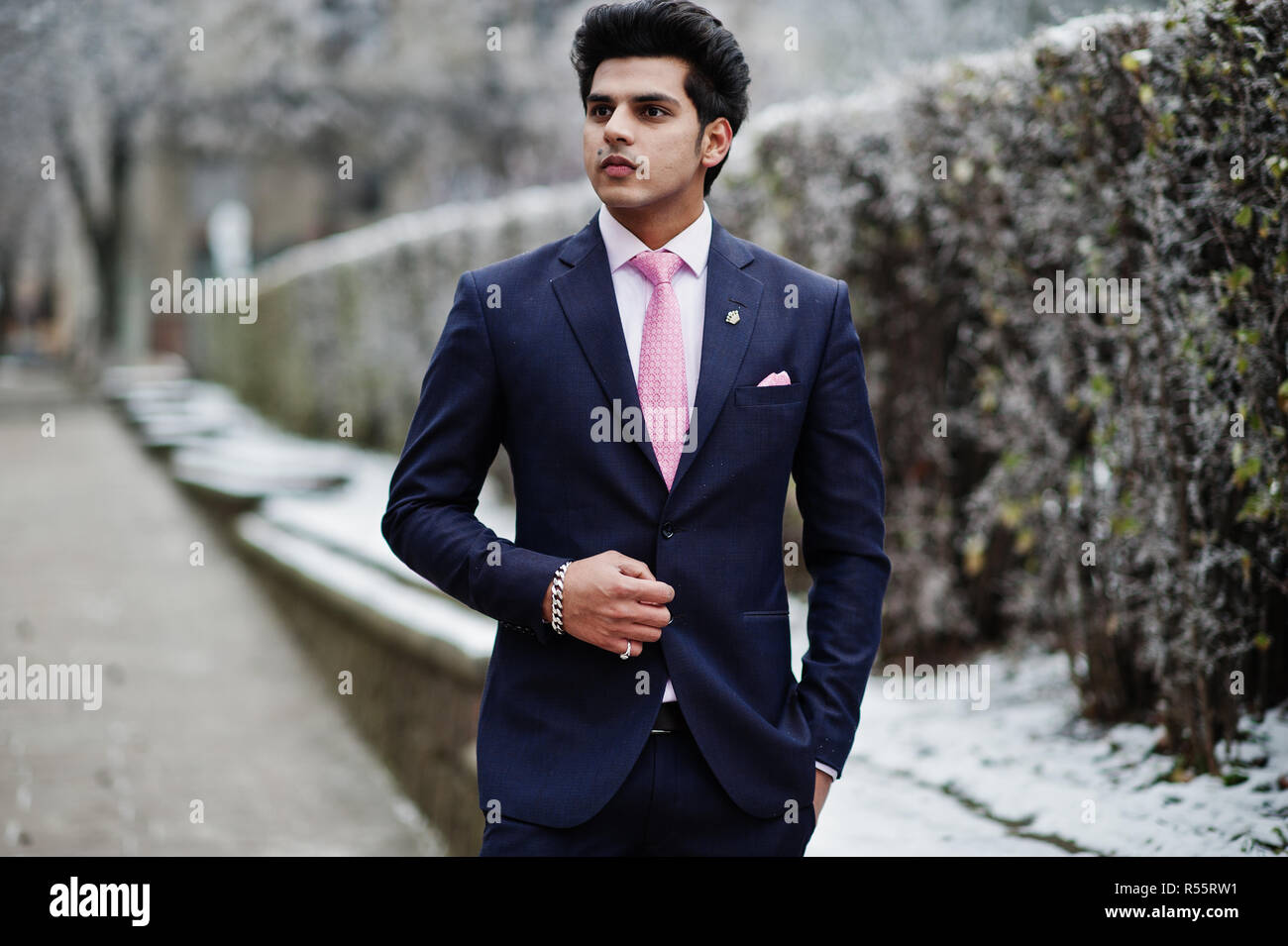 Elegant indian macho man model on suit and pink tie posed on winter day ...