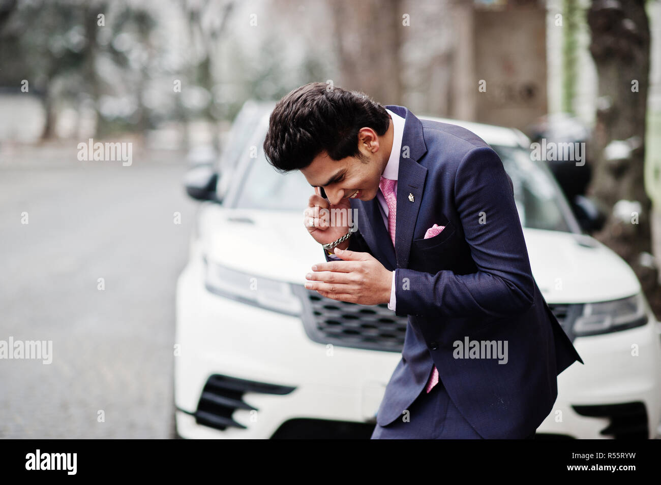Elegant indian macho man model on suit and pink tie posed against white ...